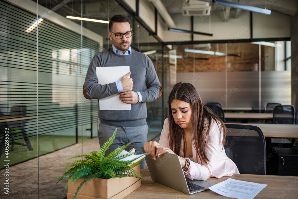 Angry boss firing upset female employee in office. Young male business ...