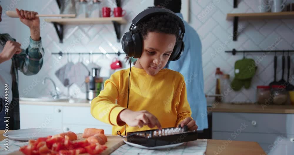 Little african talented boy wearing headphones creating music on sound ...