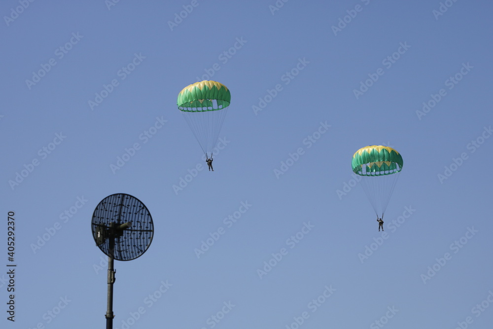 Military army parachutes paratroopers jump in blue sky from airplane ...