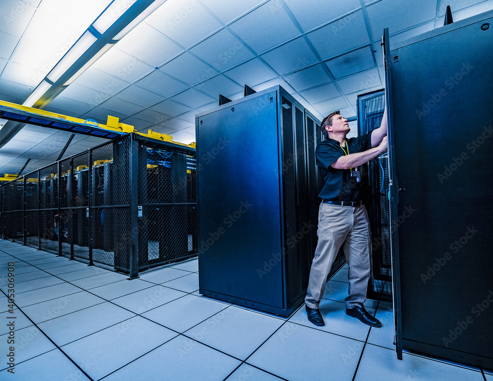 Employee working on server rack in data center Stock Photo | Adobe Stock