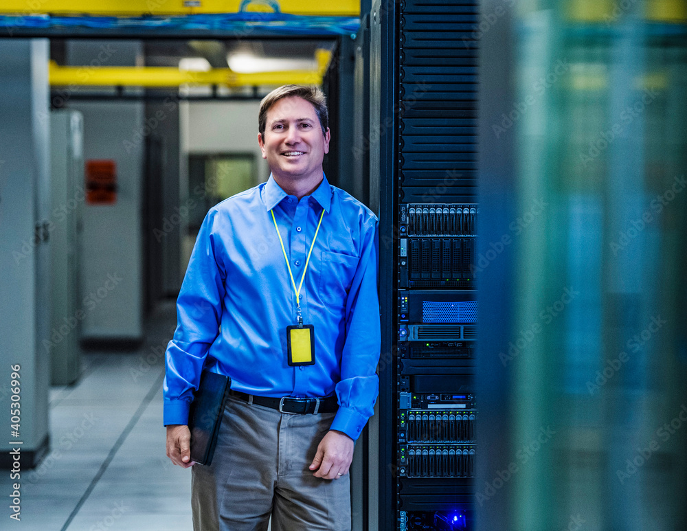 Smiling employee standing in data center Stock Photo | Adobe Stock