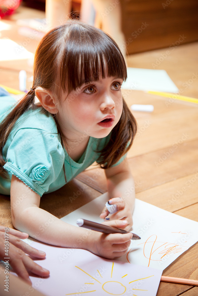 Girl lying on floor drawing Stock Photo | Adobe Stock