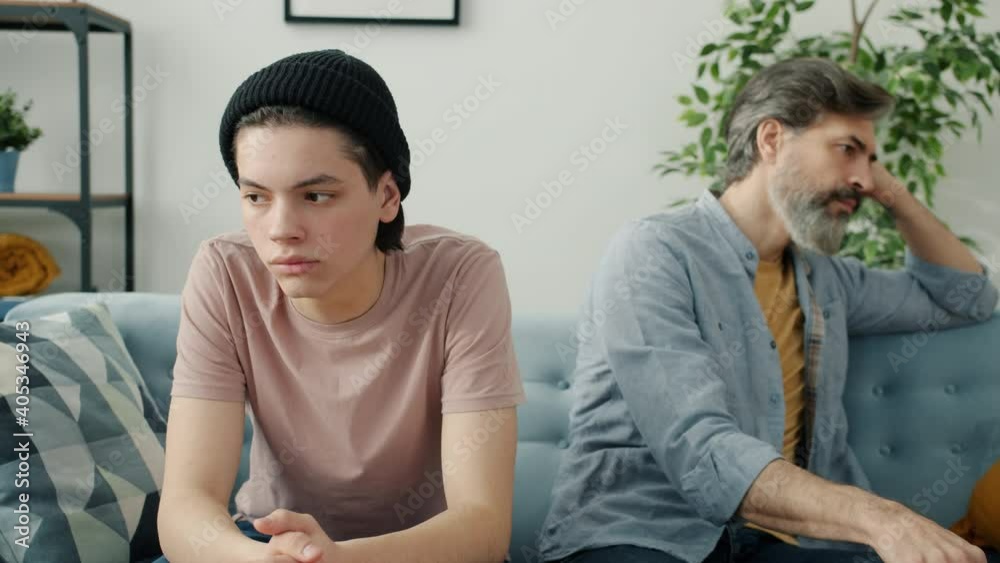 Slow motion portrait of miserable people kid and dad sitting on couch ...