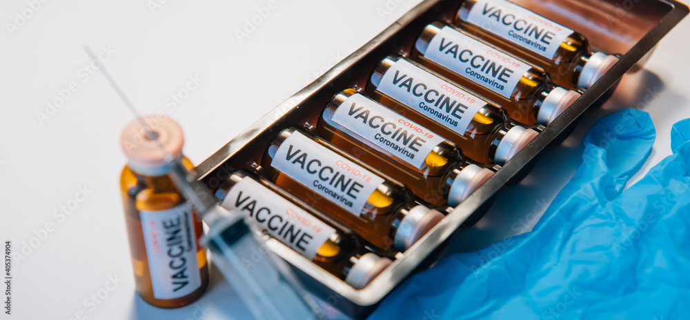 Medical syringe and vaccine in vial, box with ampules, select focus. Inscription on the label ...