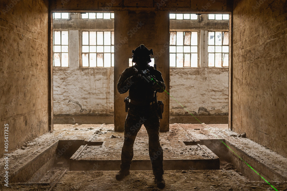Silhouette of a special forces operator in abandoned building during ...