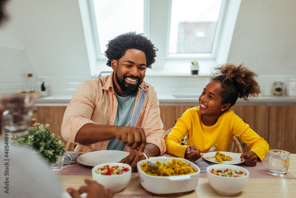 Afro father and daughter eating together at home Stock Photo | Adobe Stock