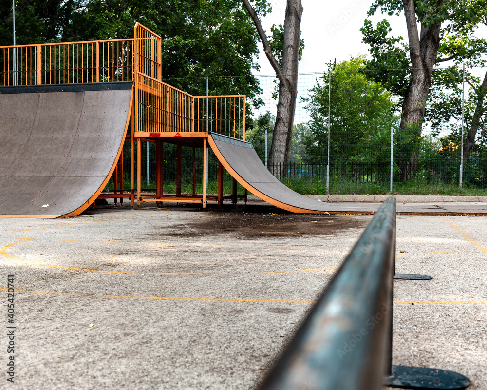 Empty skate park in summer steel framed wooden ramps, paths fences ...