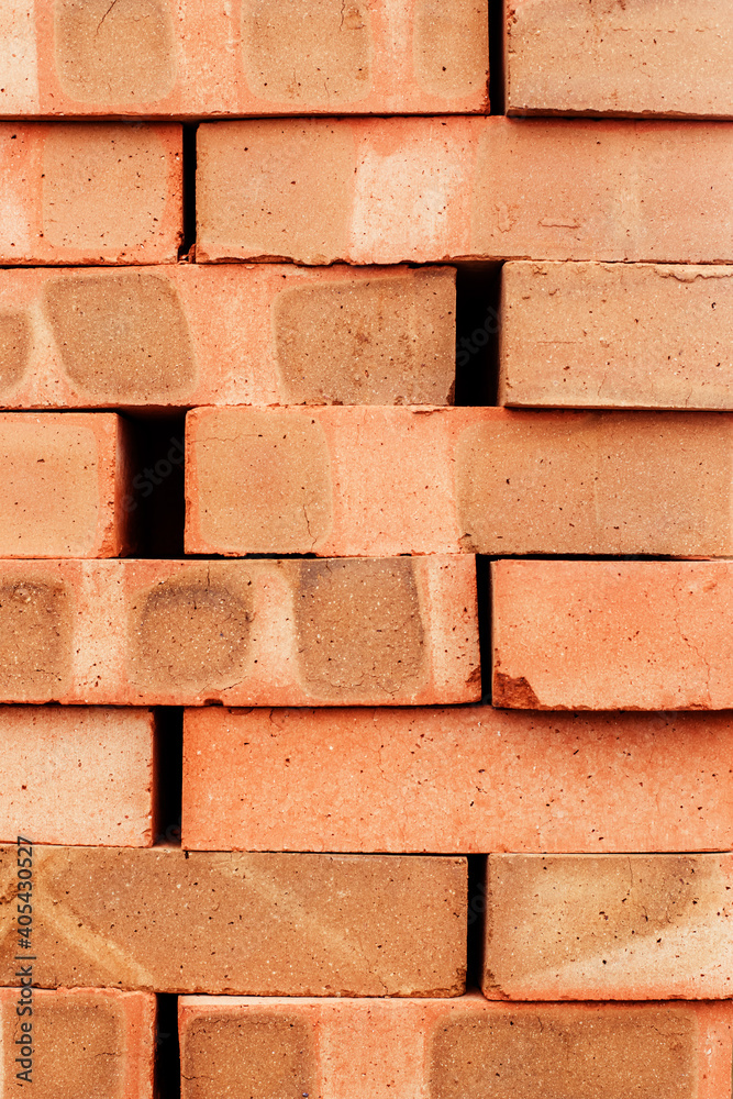 Red brick packed in stacks are stored on ground outdoors at a hardware ...