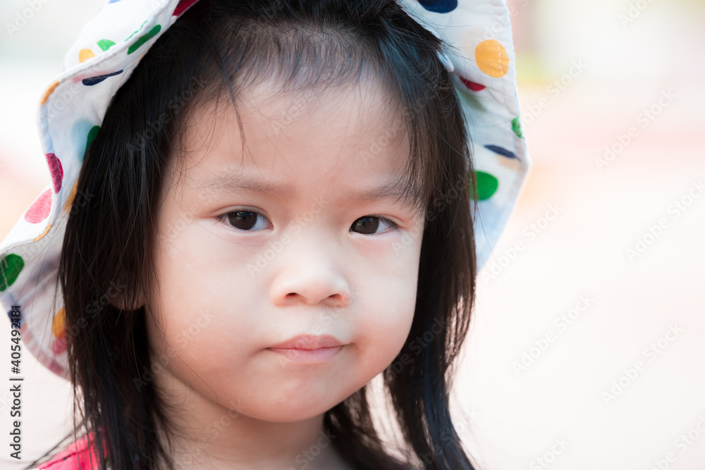 Head shot. Cute girl showed a sad expression. Asian child is in a bad ...