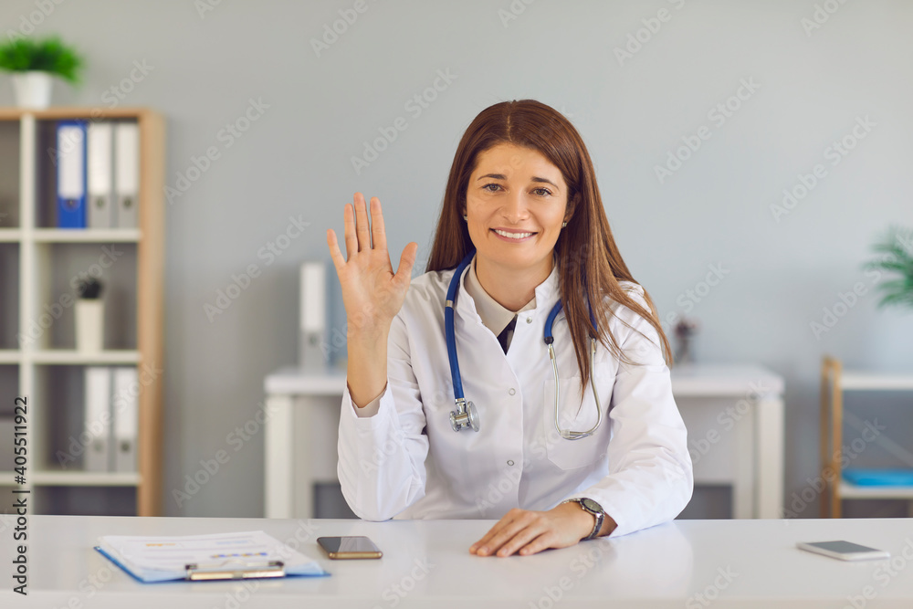 Female doctor waving hand greeting his viewers starting an online ...
