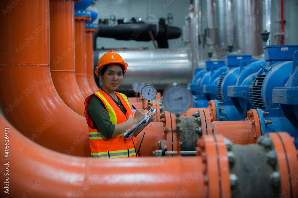 Blur Young female mechanical engineer holding drawing to checking and ...