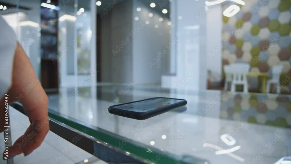 Young woman waiting in reception lobby using smartphone. Female hand ...