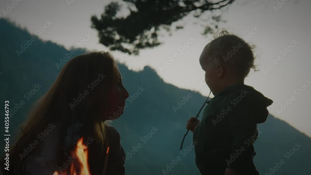 Video Stock Mom and baby son fry marshmallows on a campfire in the open ...