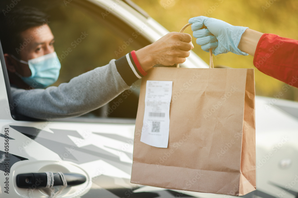 Masked man, restaurant customer, in car to pick up food on Christmas ...