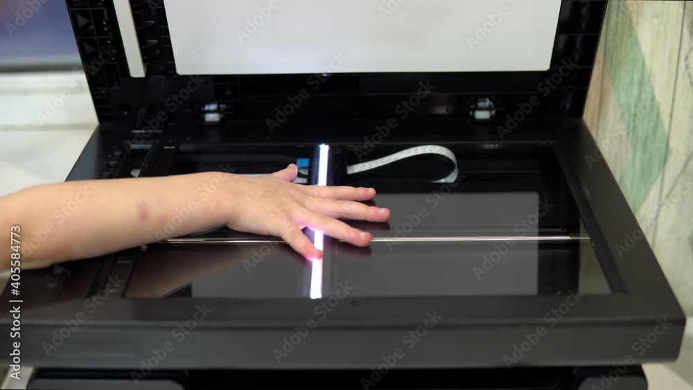 Hand scanning process. The scanner in operation scans a child's hand ...