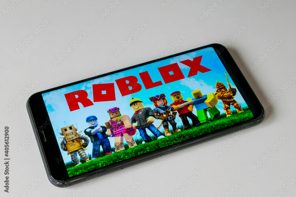 cell phone on the white table with a Roblox game screen, which is an ...