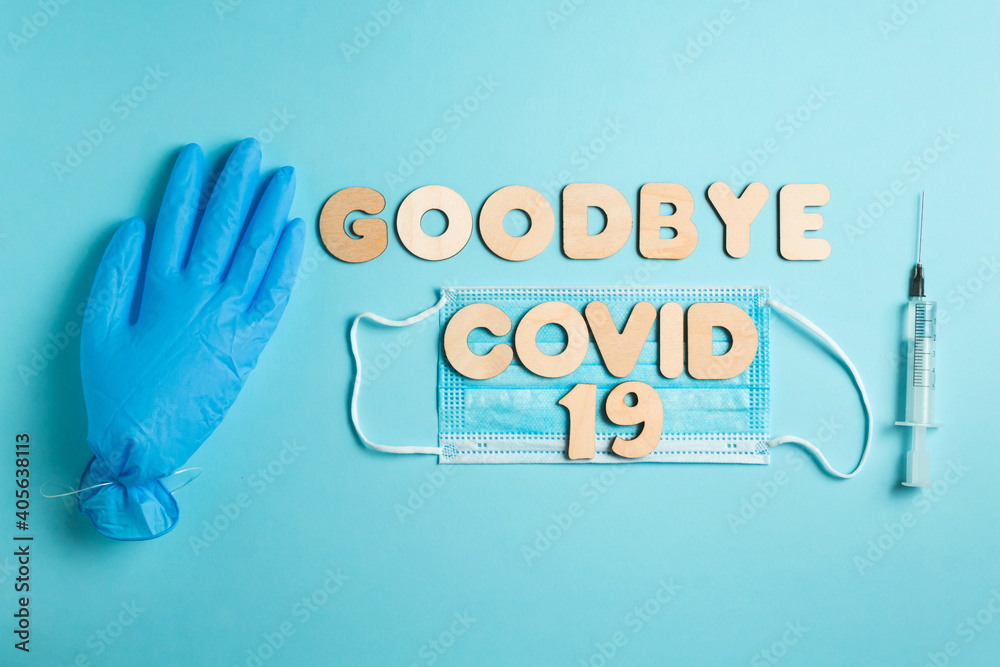 Words GOODBYE COVID 19 from wooden letters and syringe with vaccine on ...