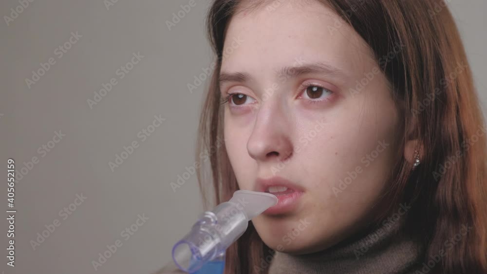 Man breathes deeply with a nebulizer to treat coughs, flu, colds. A ...