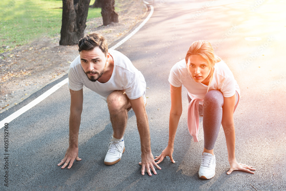 Young sport couple in starting position and hi five prepared to compete ...