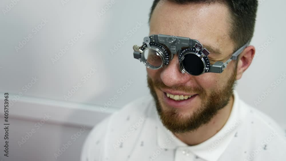 Smiling happy male patient in corrective testing glasses. Checking up ...