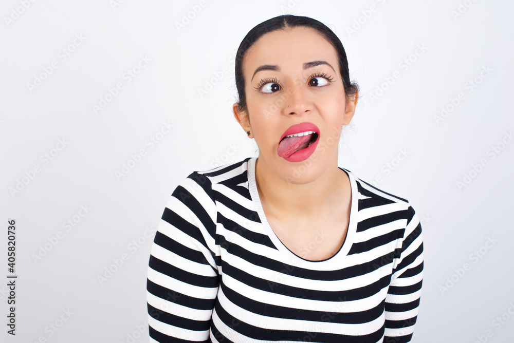 Young beautiful woman wearing stripped t-shirt against white background ...