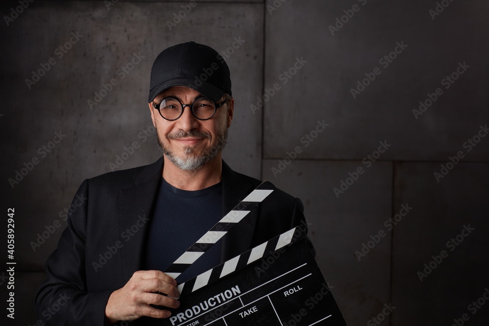 Happy man holding black clapper board. Movie director starting film ...