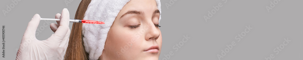 Cheek injection at spa salon. Doctor hands. Pretty female patient ...