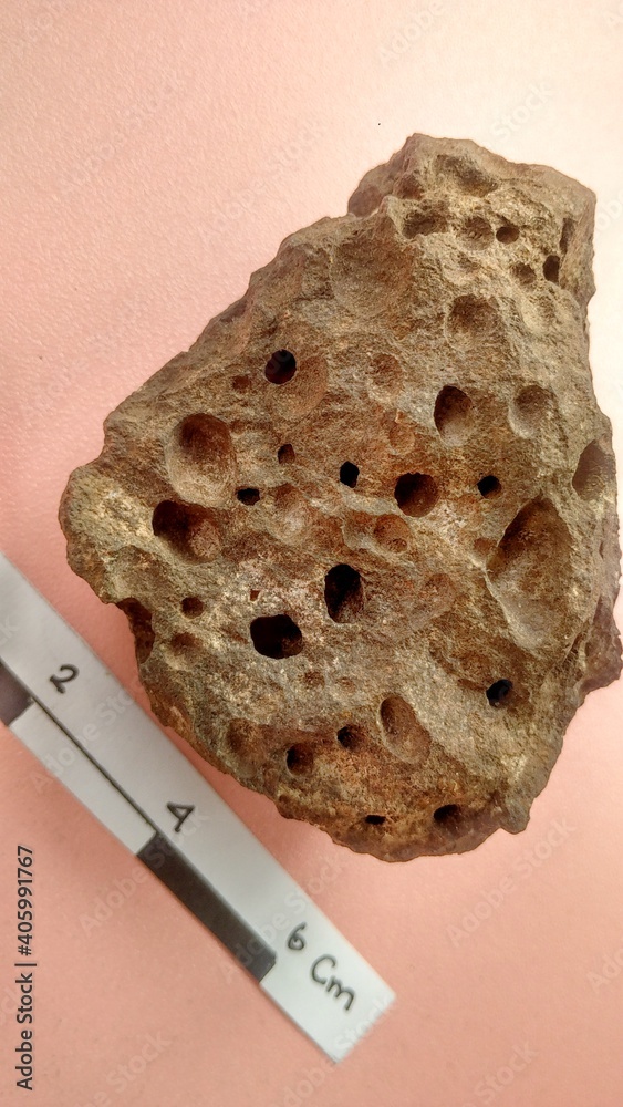 Extrusive volcanic igneous rock, vesicular basalt. Dark brown and ...