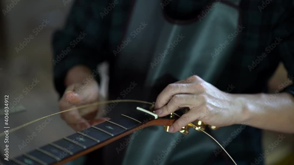 Guitar maker changing acoustic guitar strings in the carpentry guitar ...