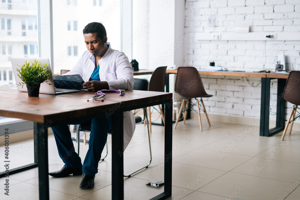 Wide shot of African American black man doctor examining MRI brain scan ...