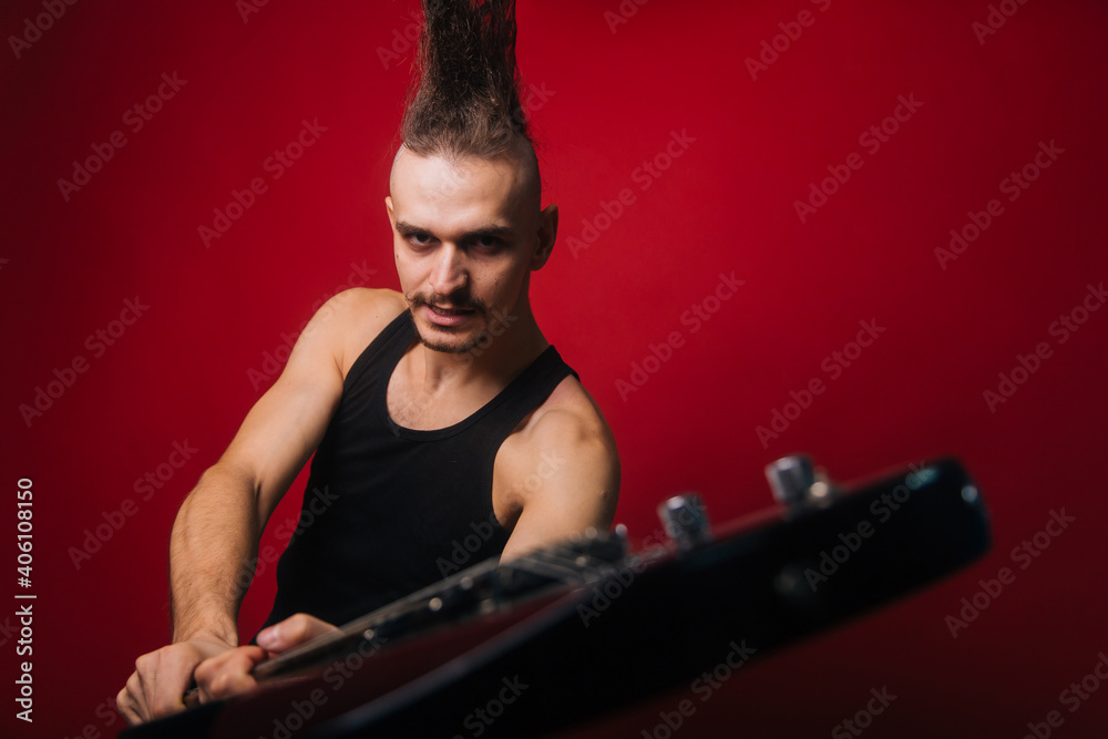 A Punk man with a black electric guitar with a mustache and a large ...