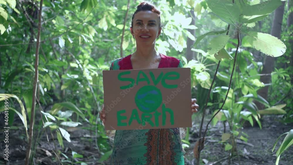An adult woman for "Save the Earth" holds a sign in her hand, she ...