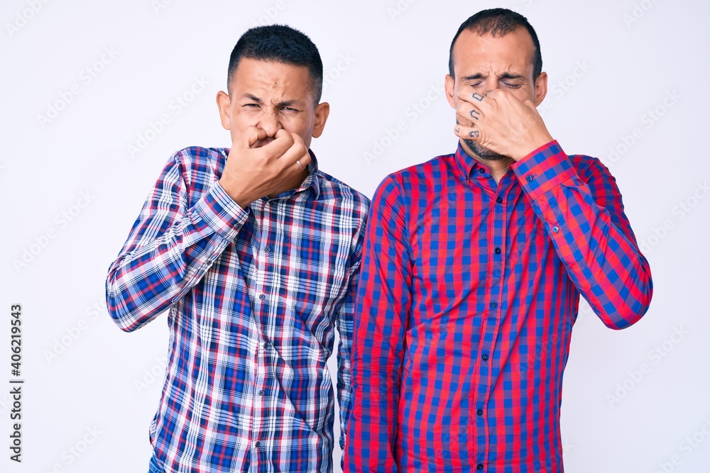 Young gay couple of two men wearing casual clothes smelling something ...