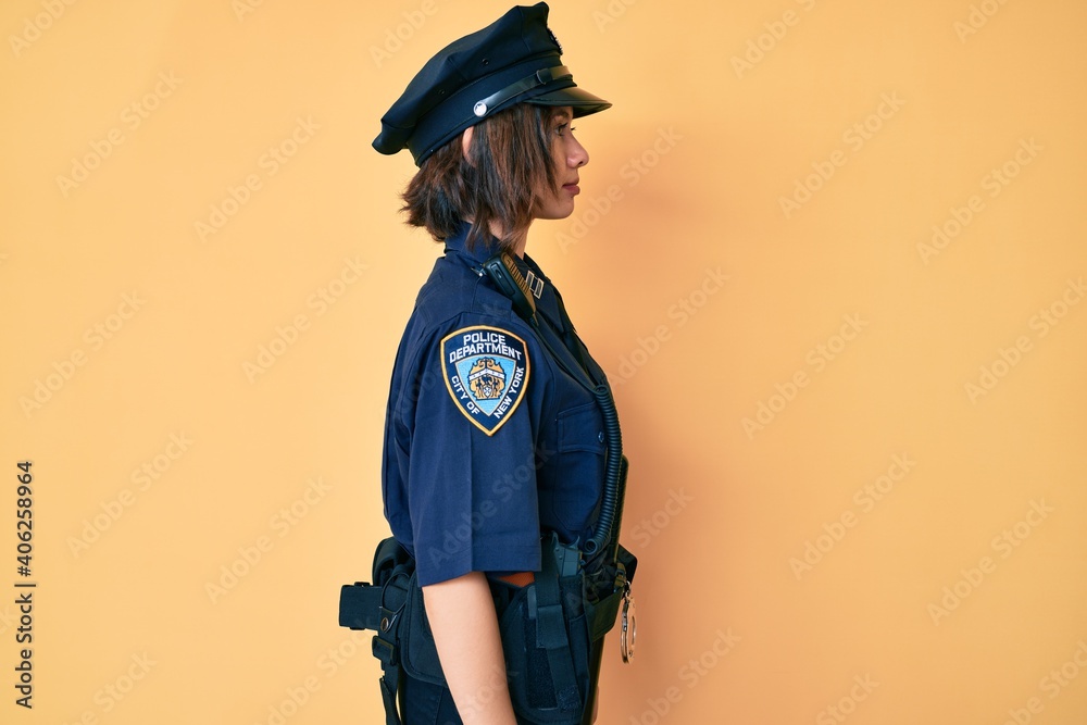 Young beautiful woman wearing police uniform looking to side, relax ...