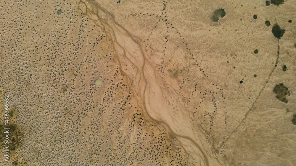 Top down view: small stream of water at the bottom of a dry lake. The ...