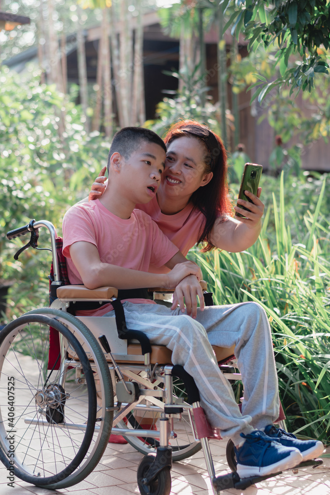 Disabled child on wheelchair and mother in nature park, Mom&Son have ...