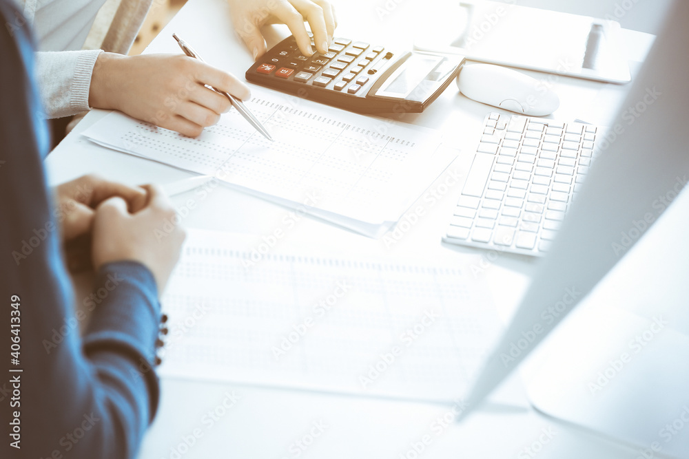 Accountant checking financial statement or counting by calculator ...