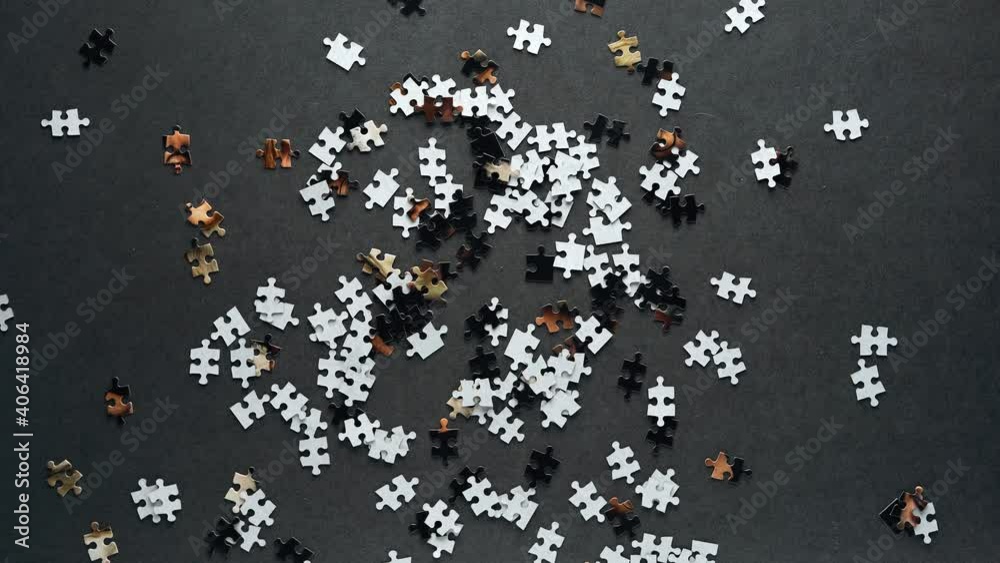 jigsaw puzzle pieces falling down onto gray table top down perspective ...