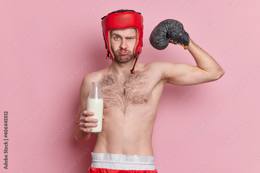 Serious man boxer with skinny body wears boxing gloves and hat raises ...