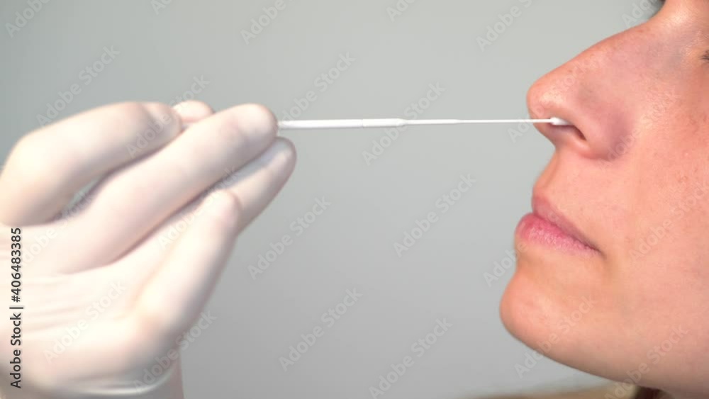 Stockvideo A nurse wearing latex gloves inserts a swab into a woman's ...