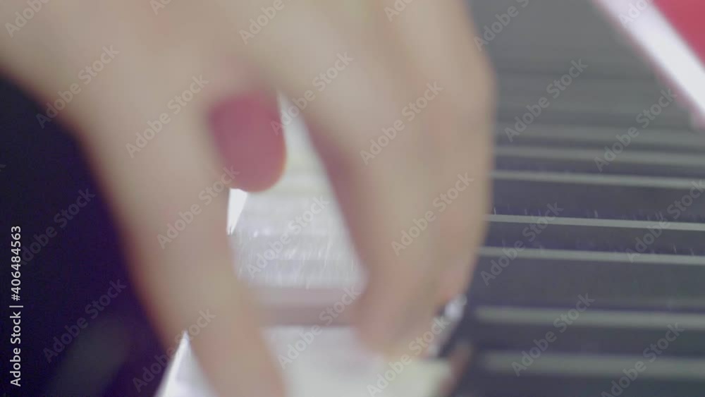 Close up of a keyboard players hand sliding up keys and landing on a ...