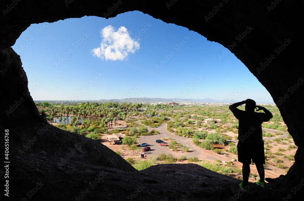A hiker's silhouette on a natural geological formation called 'Hole in ...