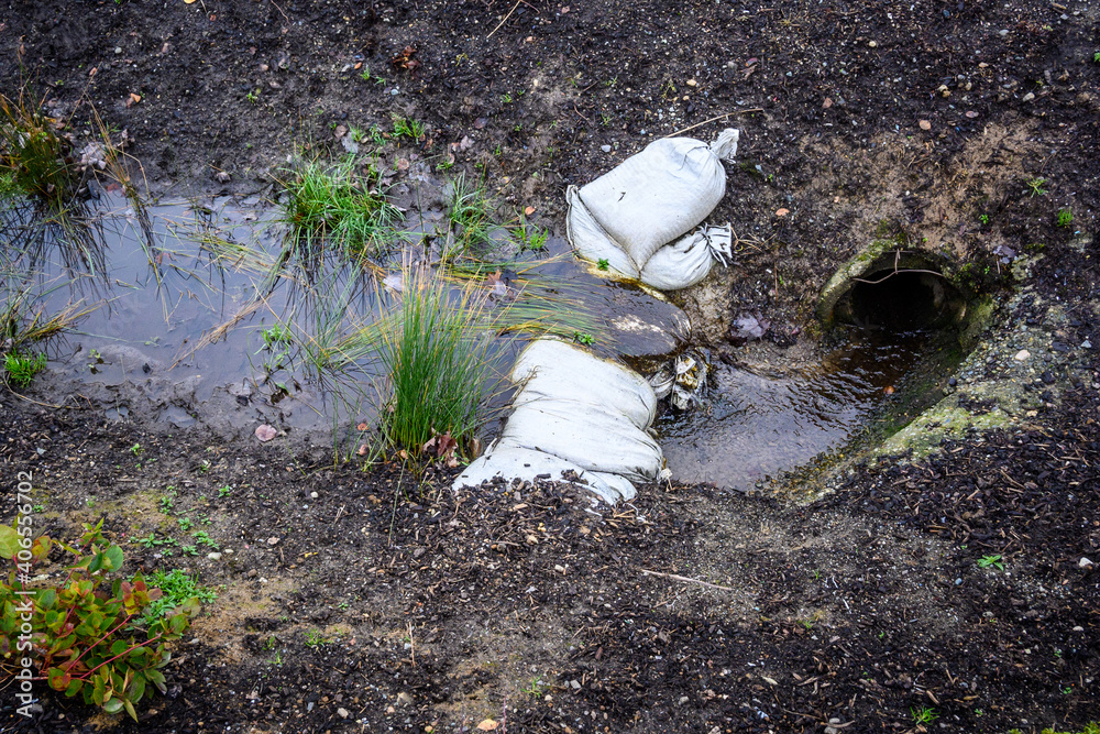 Stormwater management, inlet pipe for excess rainwater, sandbags, and ...