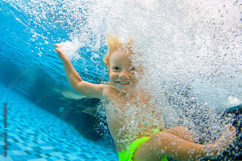 Funny portrait of child learning swimming, dive in blue pool with fun ...