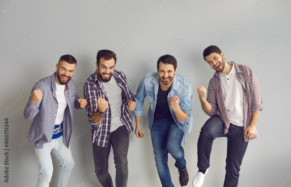 Yes we did it, we're winners. Group of 4 cheerful friends celebrating ...