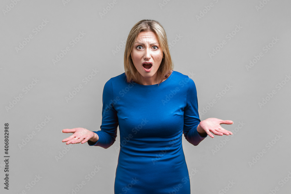 What do you want? Portrait of irritated angry woman in tight blue dress ...