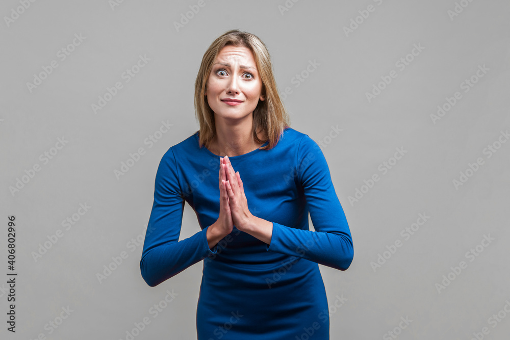 Please! Portrait of upset woman in elegant blue dress holding hands in ...