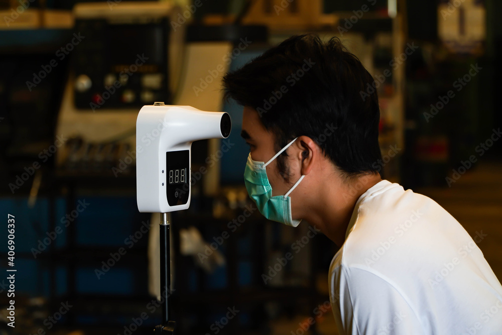 Asian men use digital infrared thermometers to measure body temperature ...