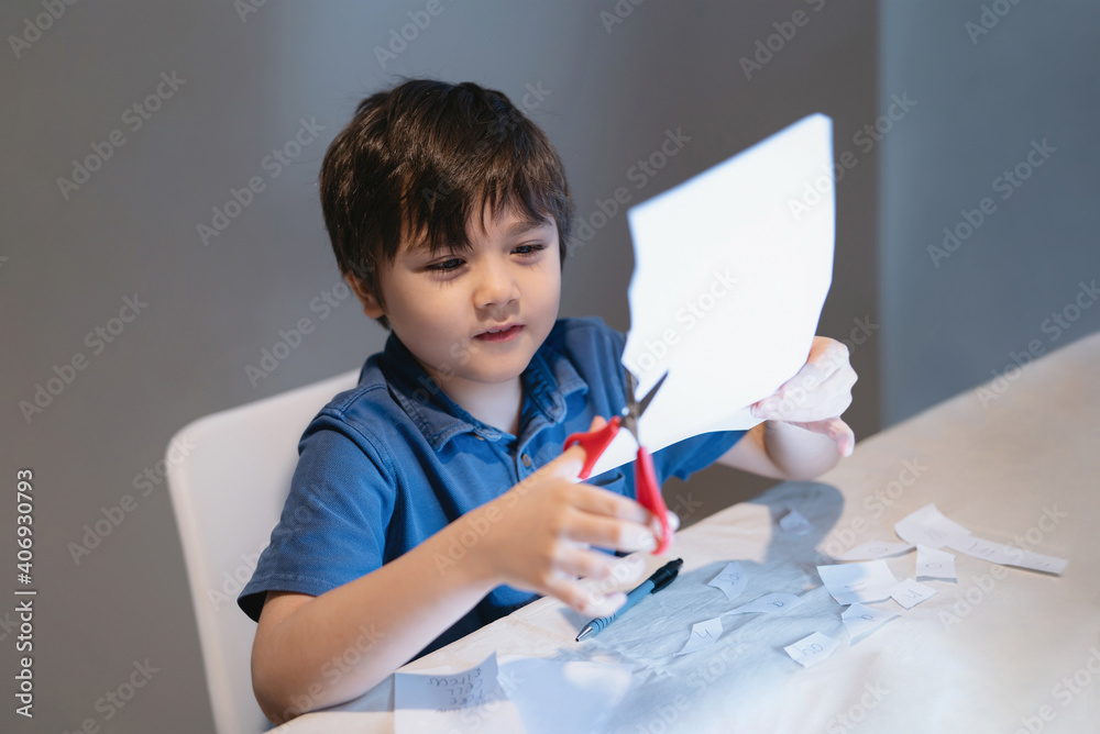 Kid using scissors cutting white paper , schoolboy making art and craft ...