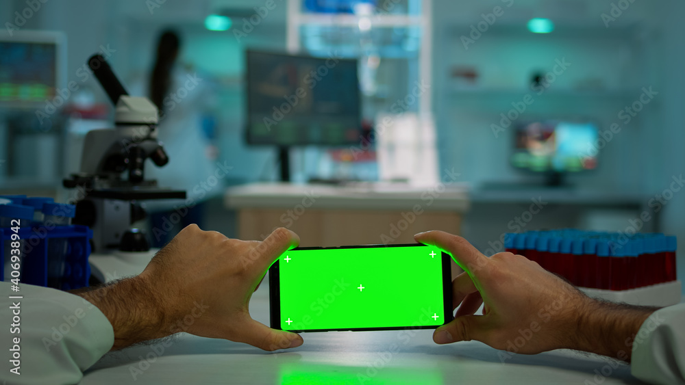 POV shot of chemist using horizontal smartphone with chroma key on ...